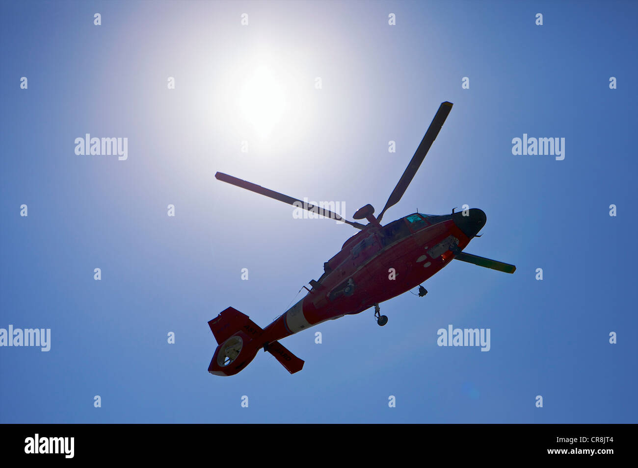 Coast Guard helicopter flying past the sun on a clear day Stock Photo ...