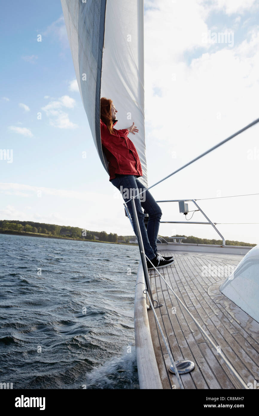 Woman leaning against sail on yacht Stock Photo - Alamy