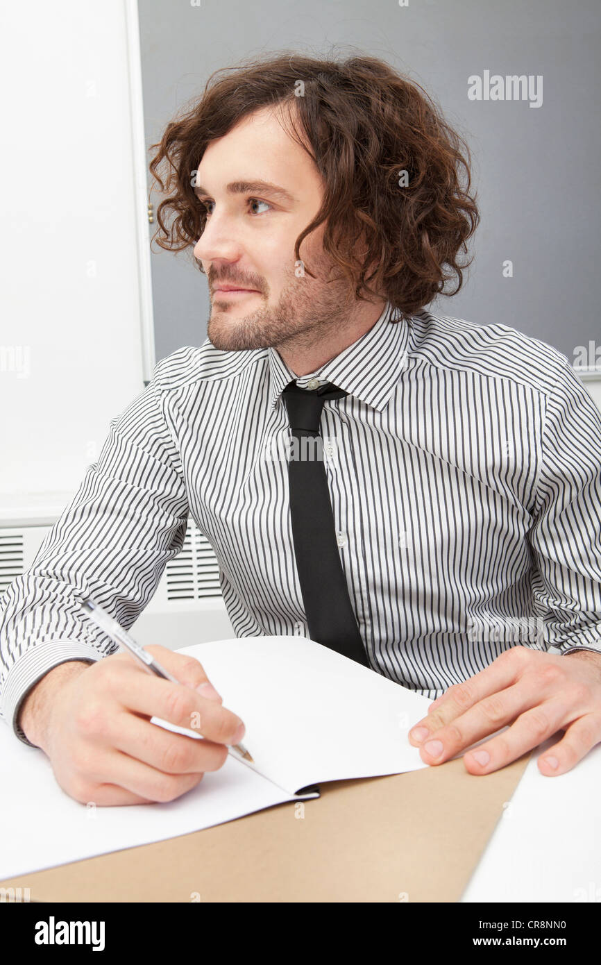 Office worker writing in notebook Stock Photo - Alamy