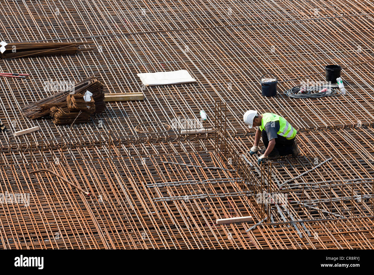 Construction worker installing steel rebar beams for reinforced ...