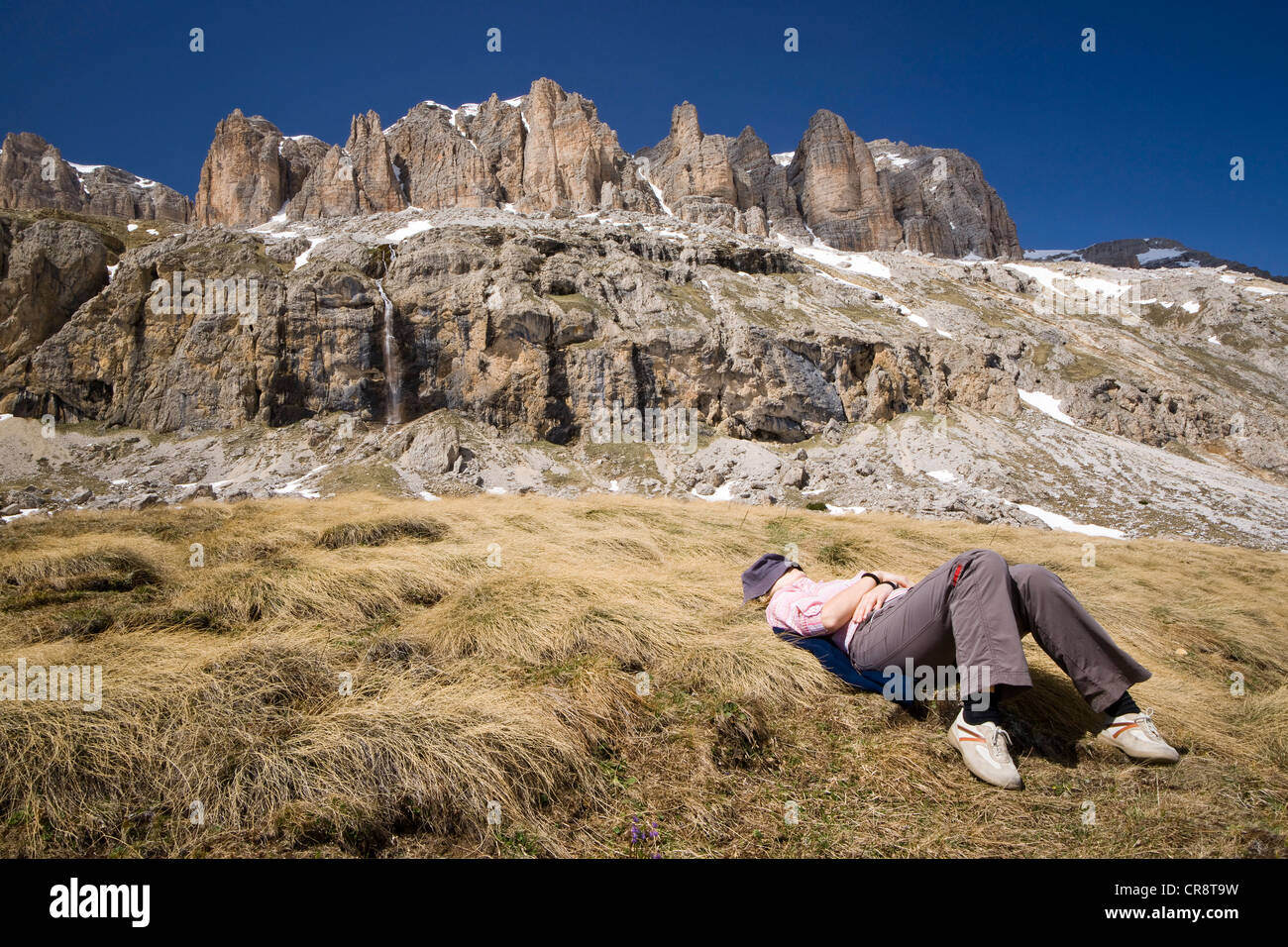 Young woman resting in front of Mount Sella, Dolomites, Italy, Europe ...