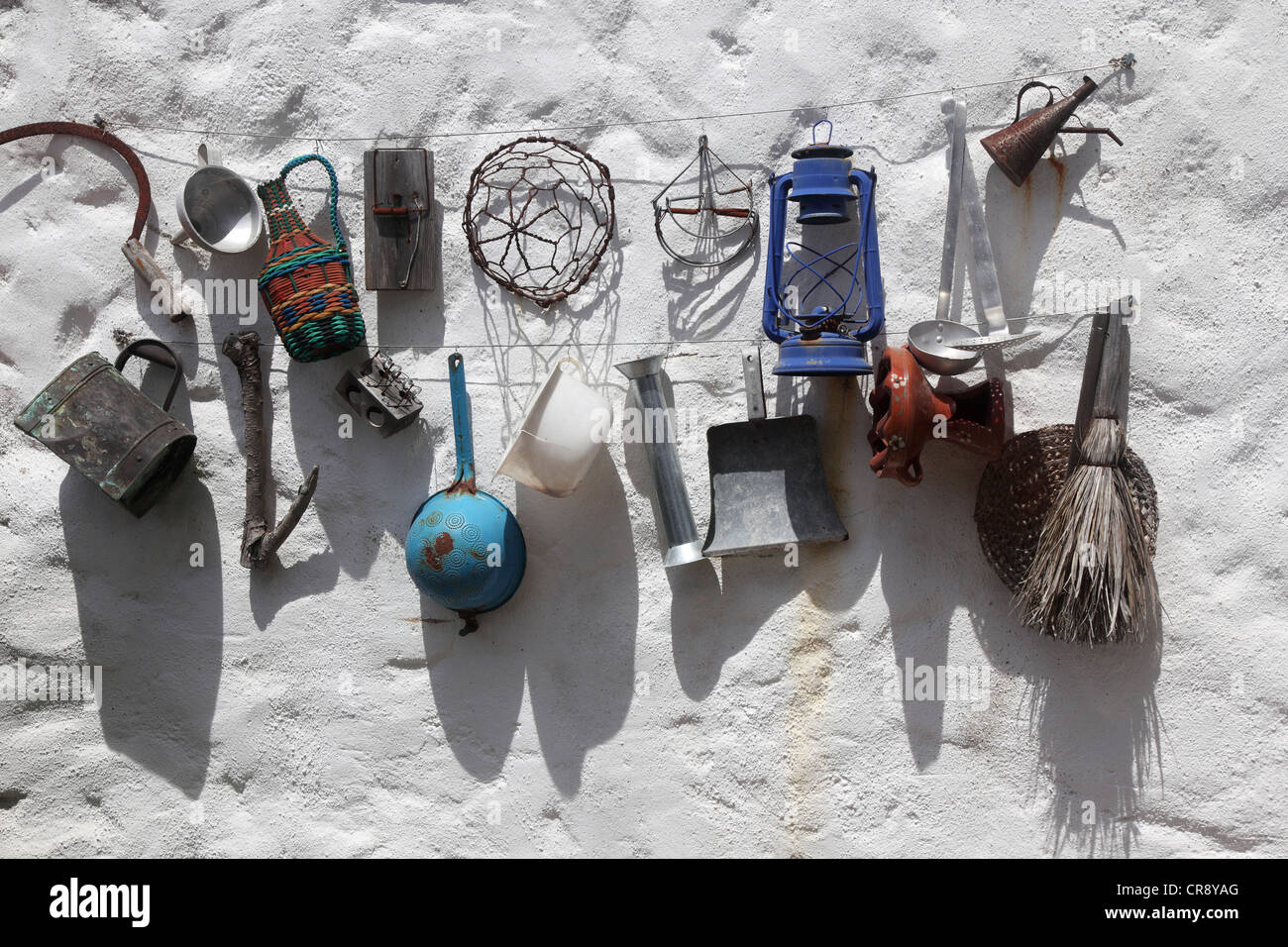 Farm instruments and tools hang on a line in the village of Aldeia da ...