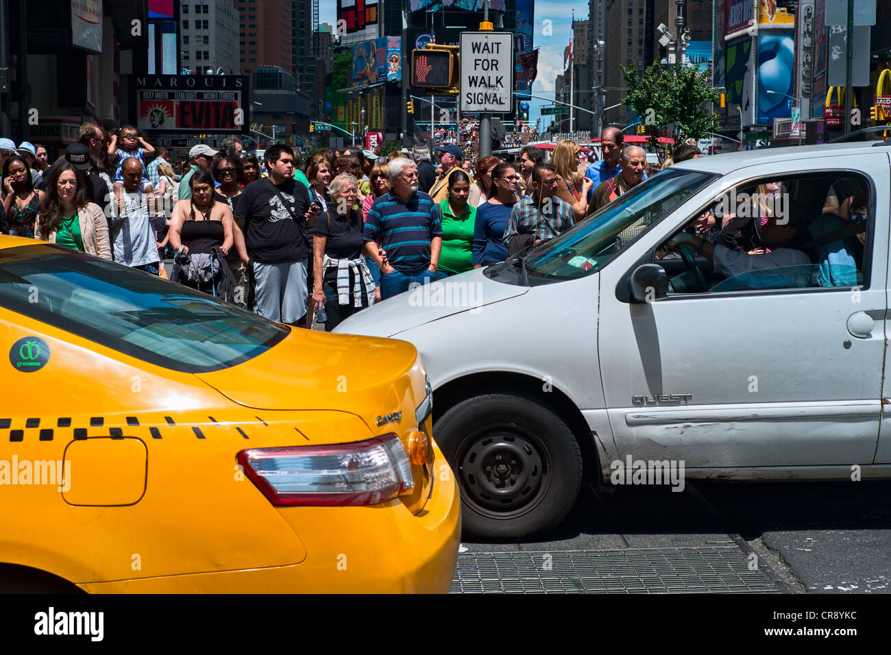 Cars passing in front of large crowd of waiting pedestrians, Times ...