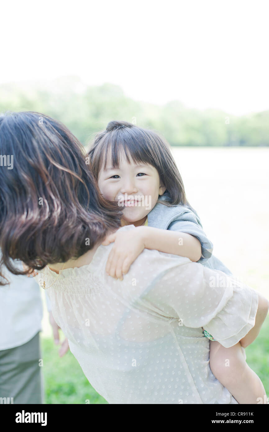 A girl on mother's back Stock Photo - Alamy