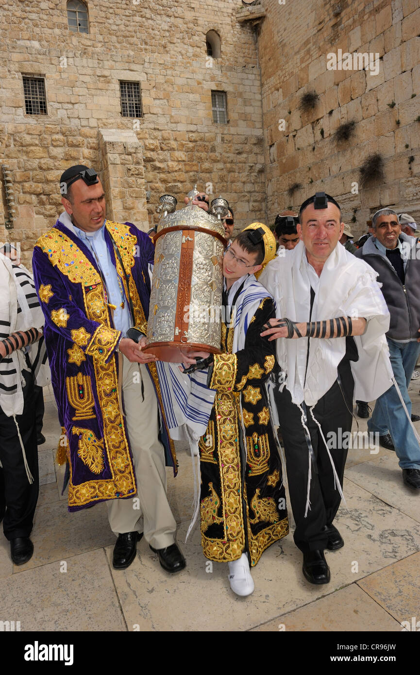 13-year old teenager in festive attire carrying a torah with his ...