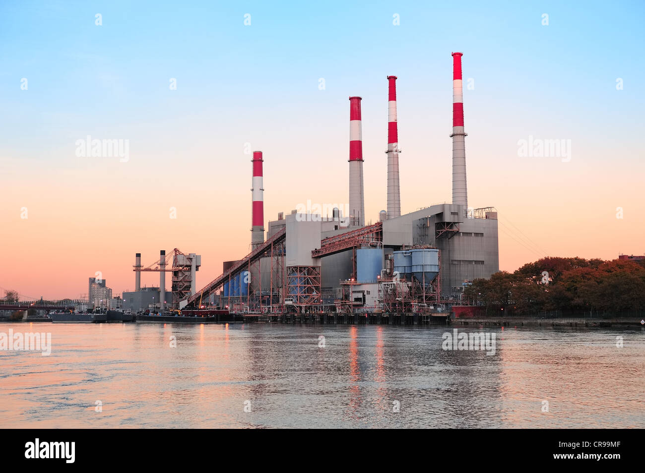 Factory over river at dusk Stock Photo - Alamy