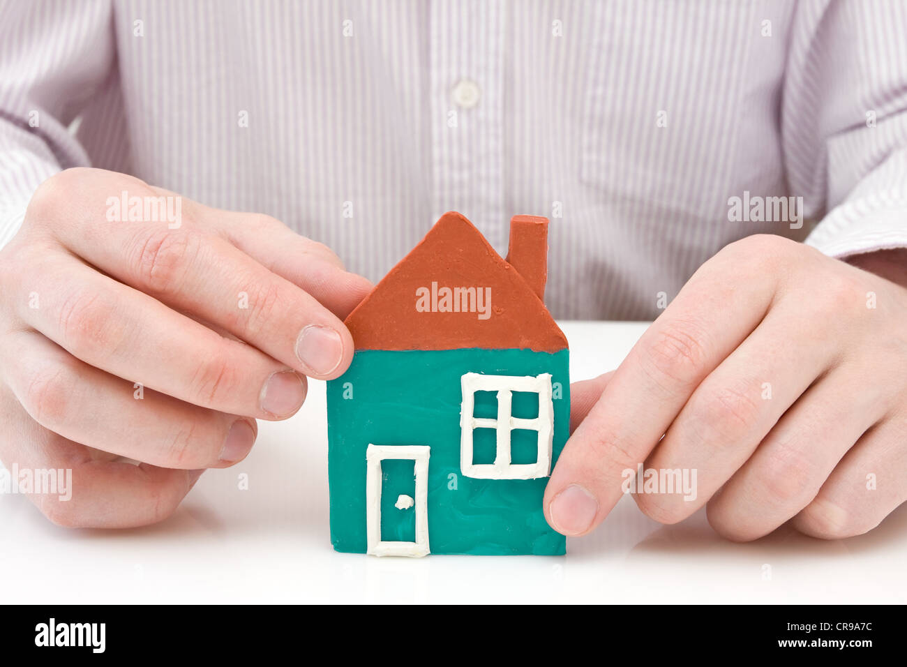 real estate concept. hands making house from plasticine Stock Photo - Alamy