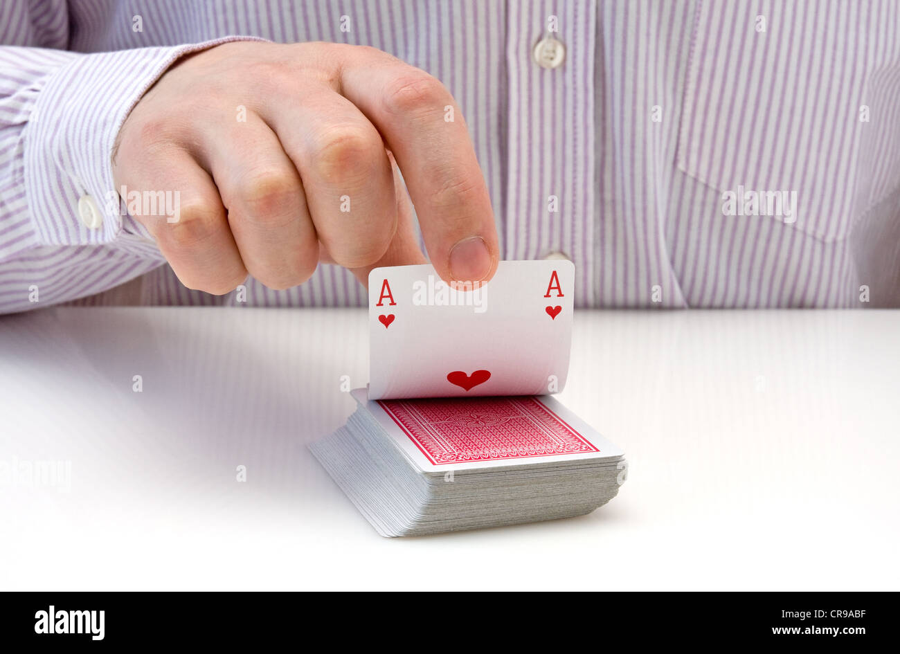 Man's hand lifting up playing card - ace of hearts Stock Photo - Alamy