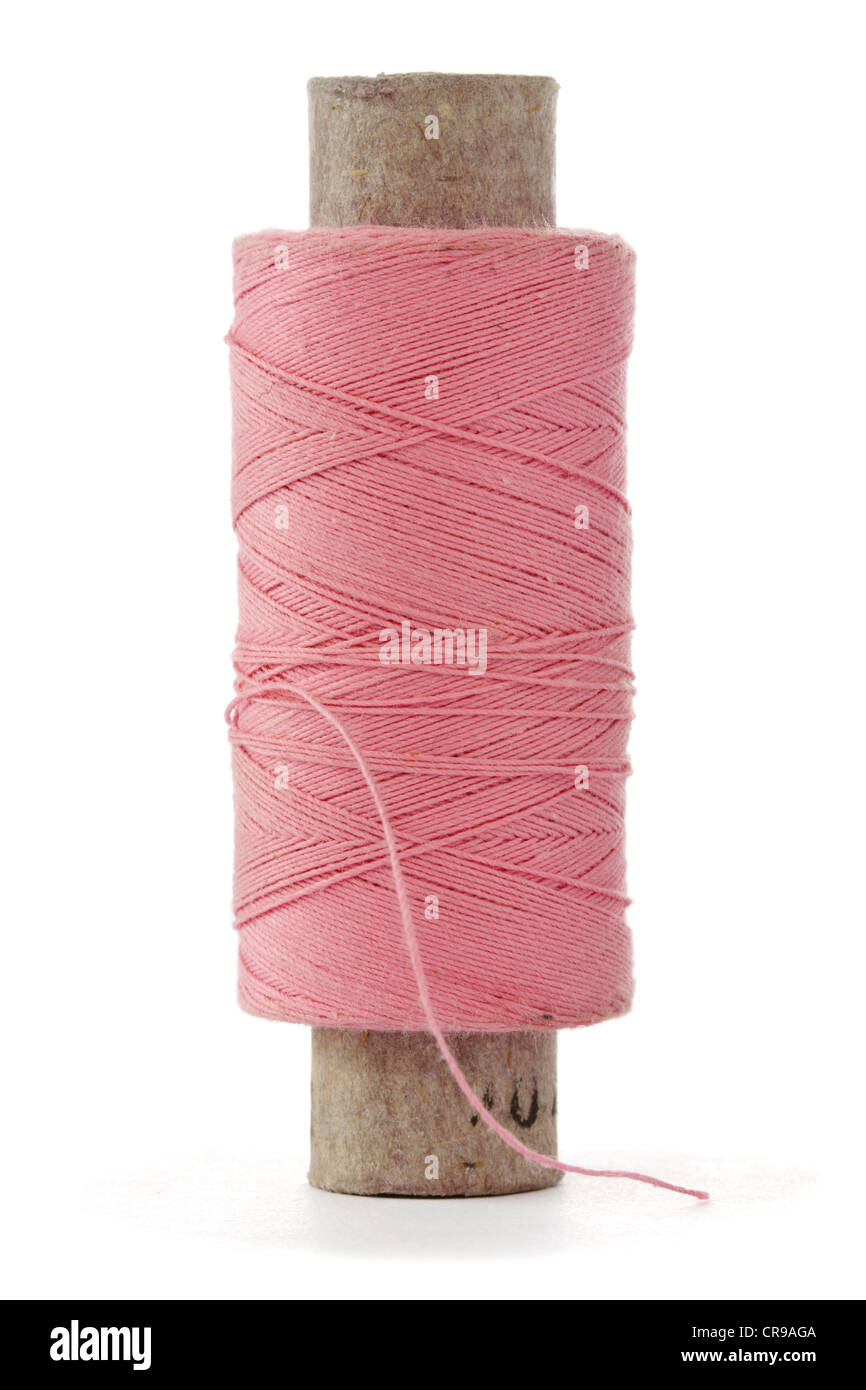 pink bobbin thread over a white background Stock Photo - Alamy