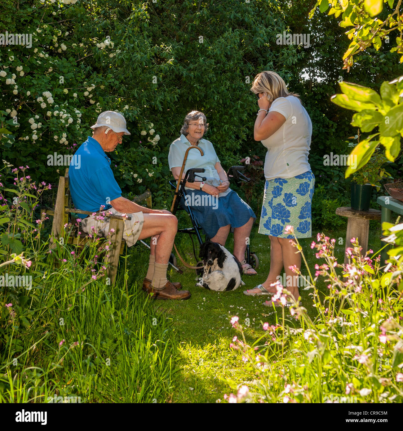 A woman in her 30's talks to her parents in law in their 70's in a Uk ...