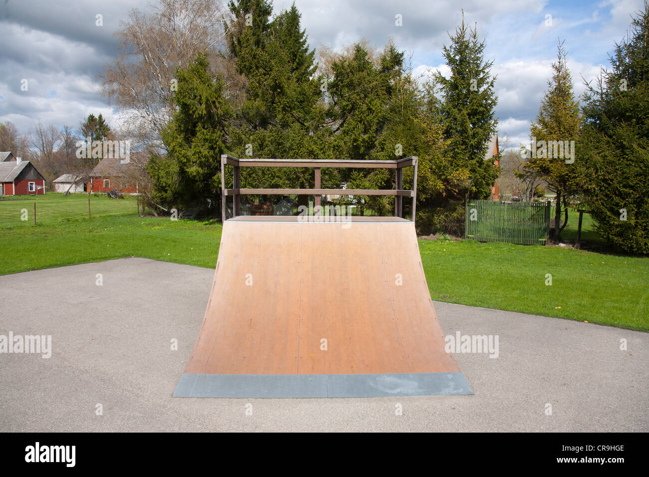 A public park. A slope and slide for skateboarders. A ramp. Trees and ...
