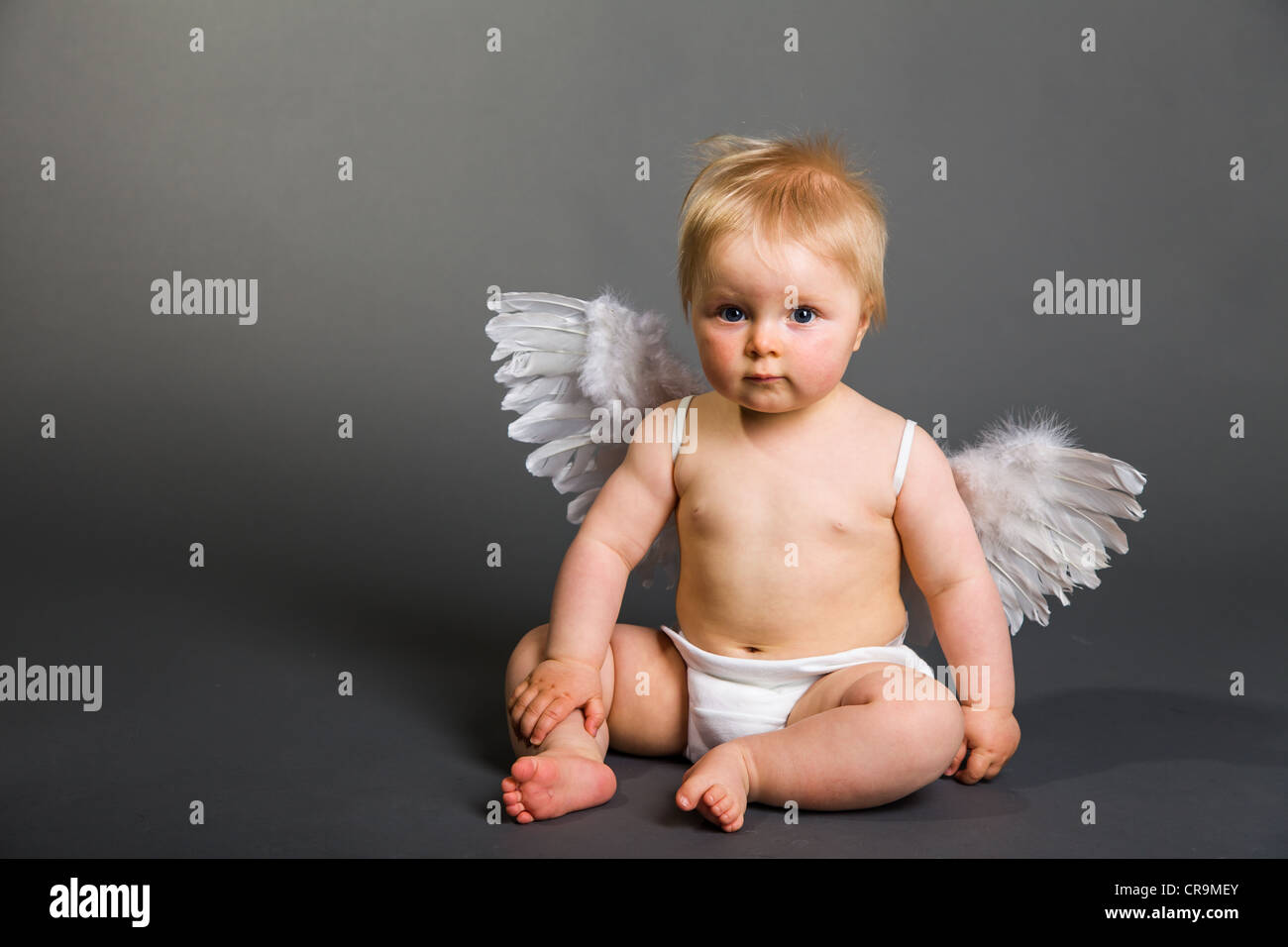 Infant angel on gray background Stock Photo - Alamy