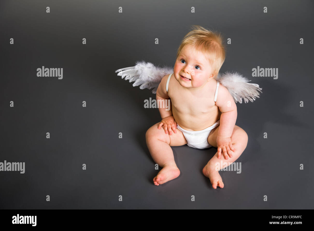 Infant angel on gray background Stock Photo - Alamy