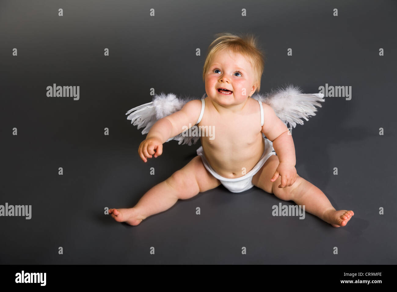 Infant angel on gray background Stock Photo - Alamy
