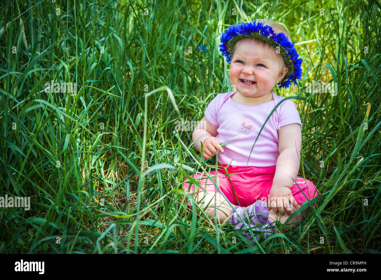 Infant child on green grass Stock Photo - Alamy