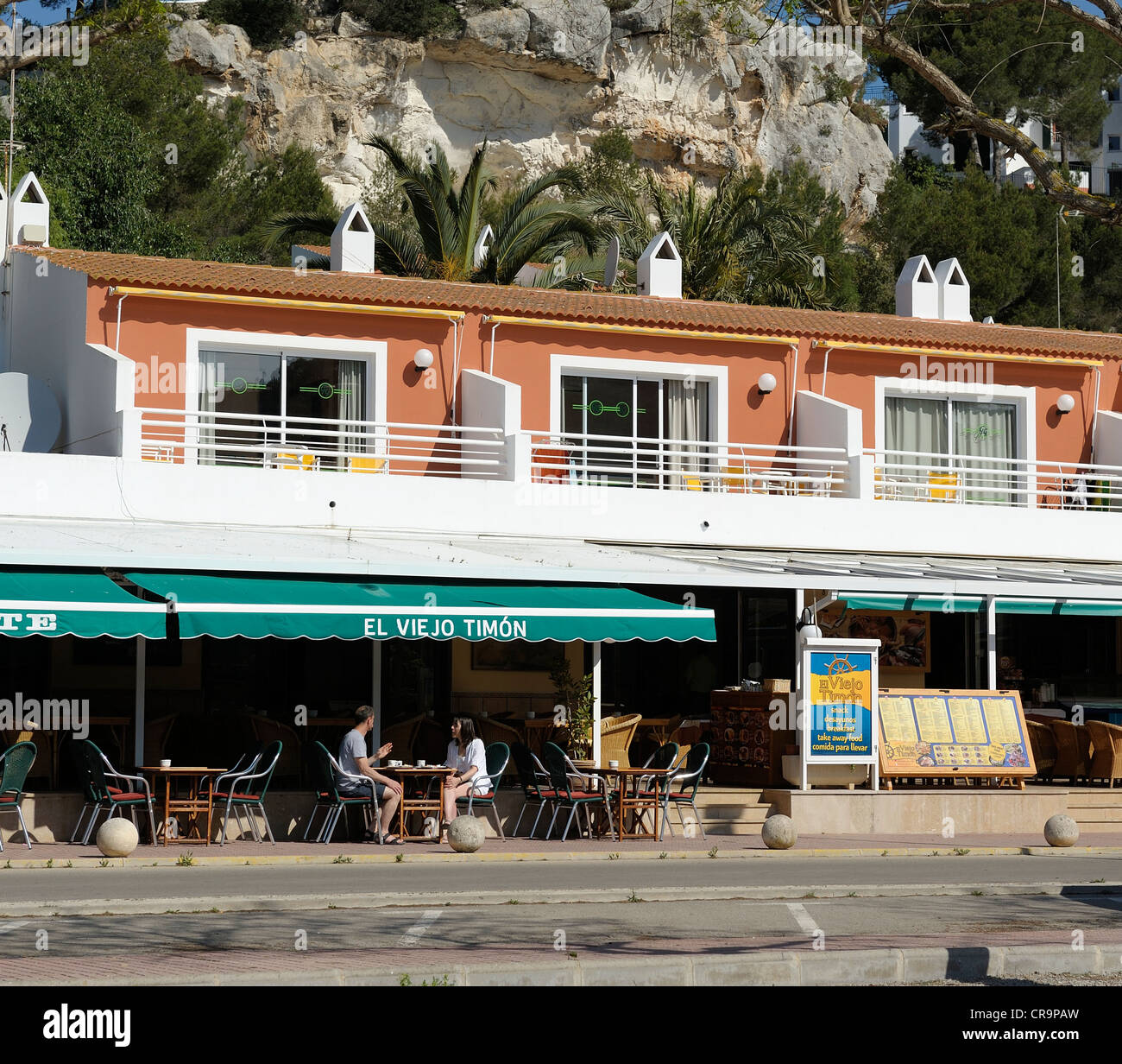 2 tourists eating and drinking in a sea front café restaurant cala ...