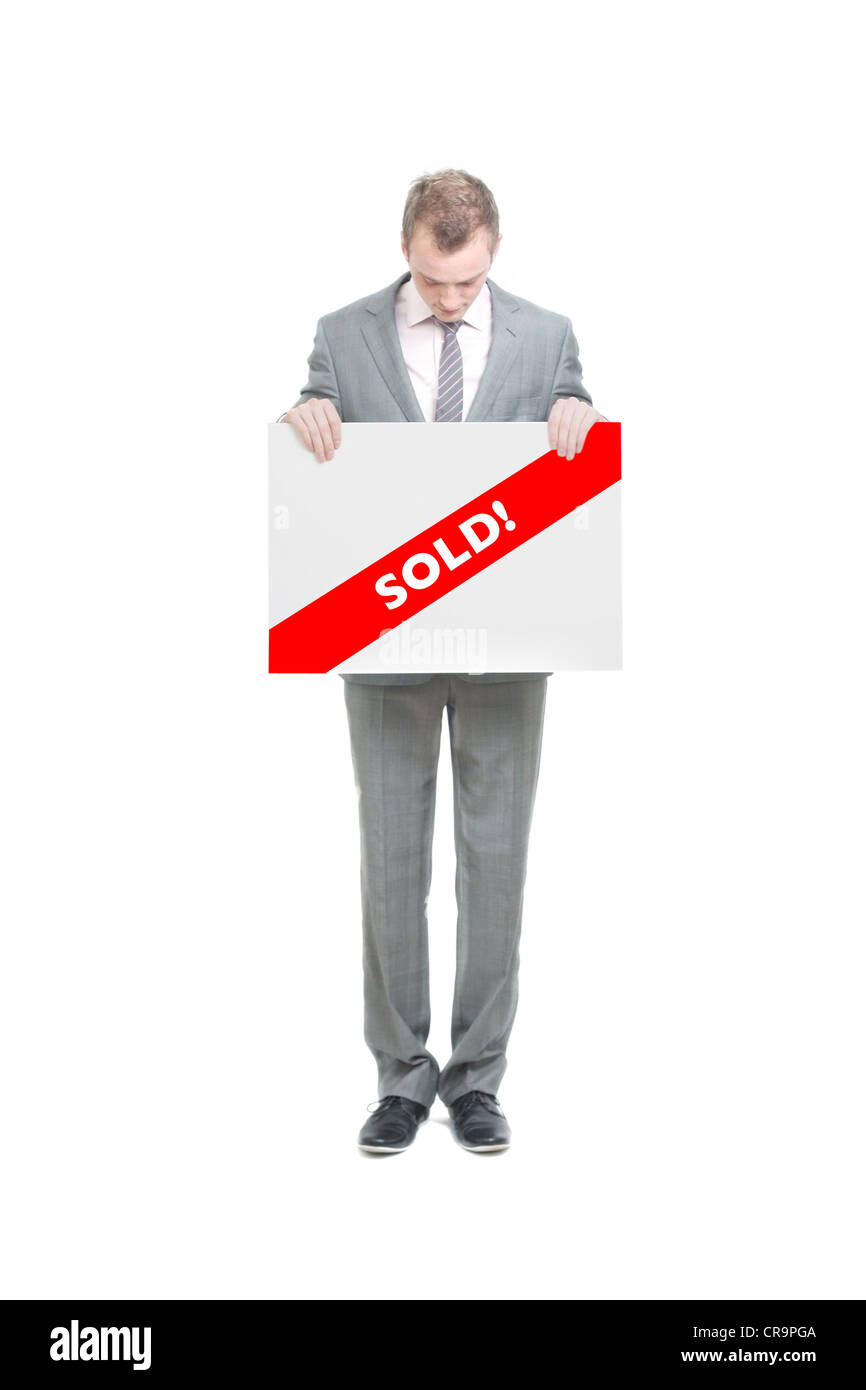 A business man with a sold sign Stock Photo - Alamy