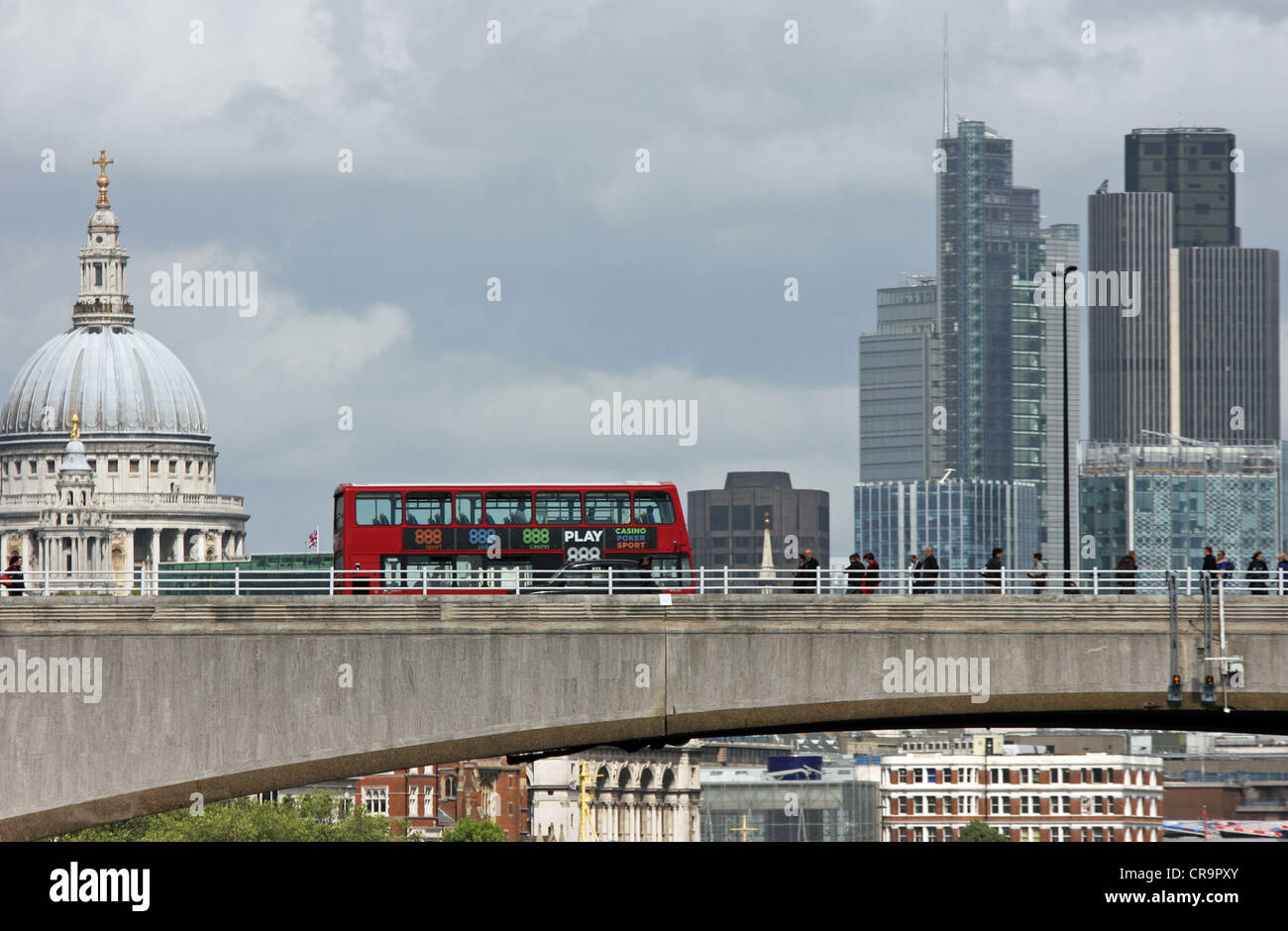 Red double decker bus going over Waterloo Bridge in London with St ...