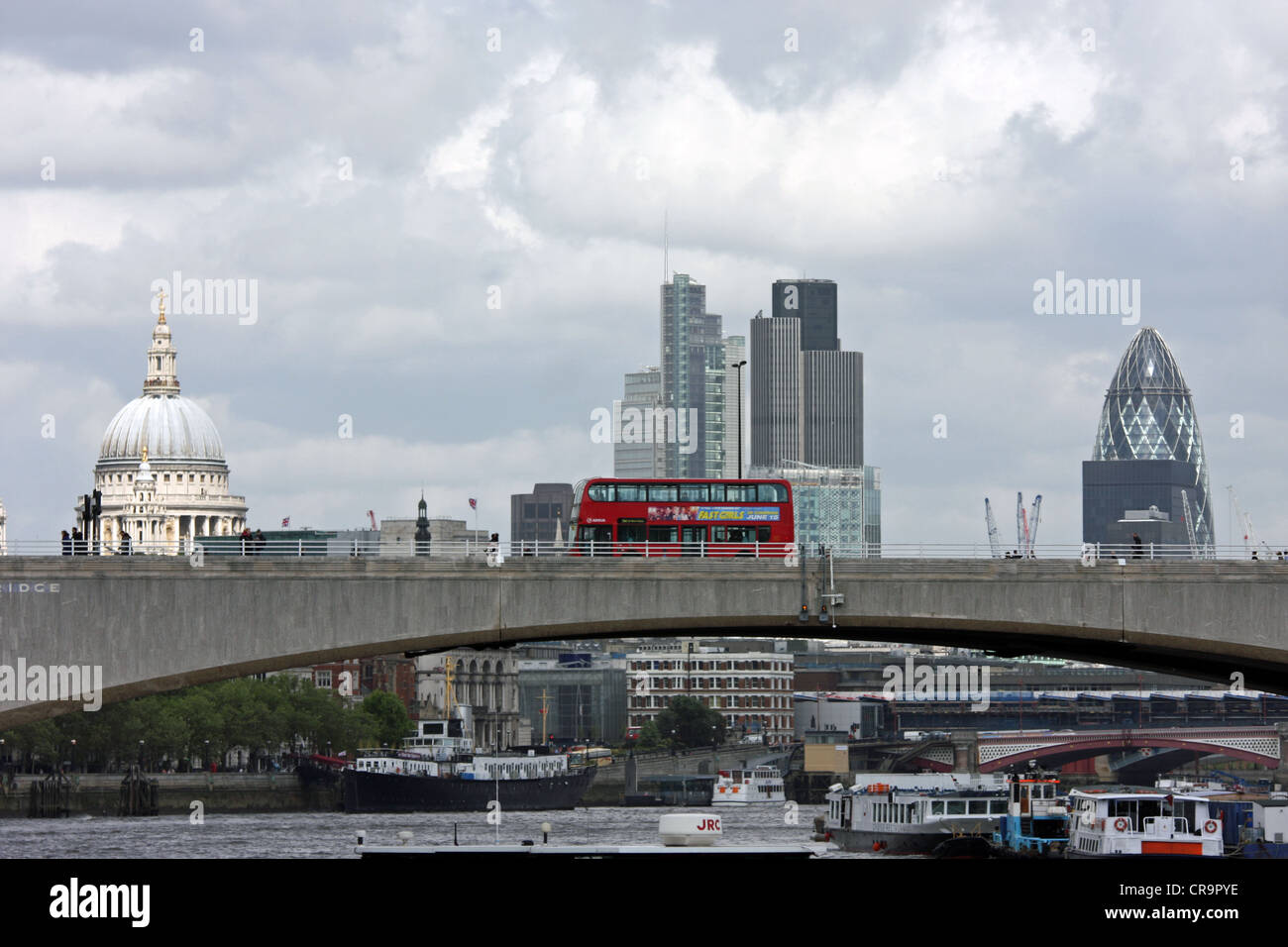 Red double decker bus going over Waterloo Bridge in London with St ...