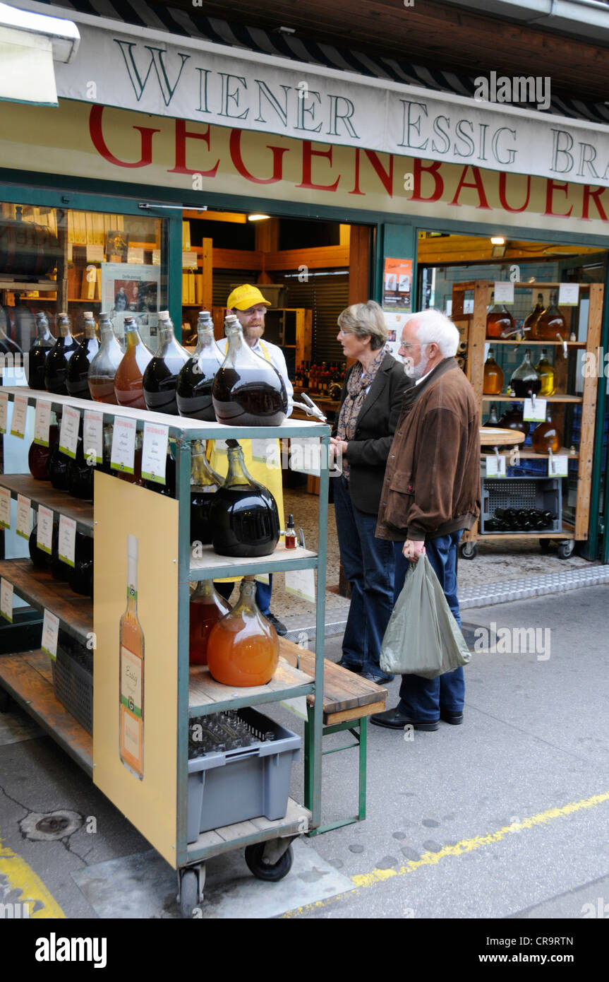 A couple out shopping admiring a display of rows of bottles filled with ...