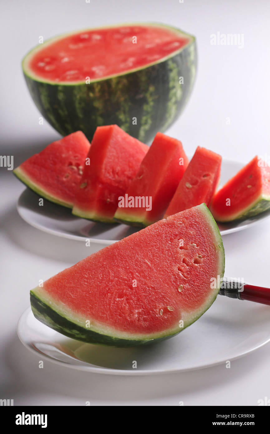 Watermelon halved and sliced on white plates Stock Photo - Alamy