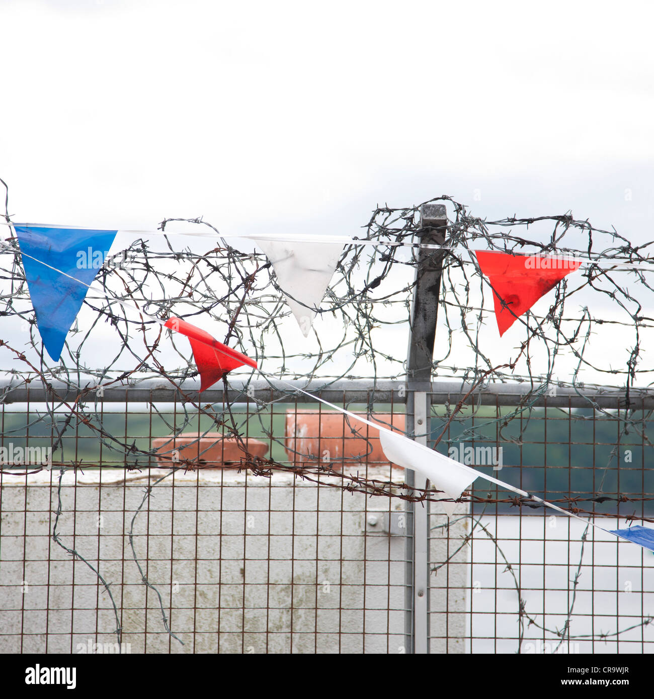 Barbed wire fence decorated with blue red and white bunting flags for ...