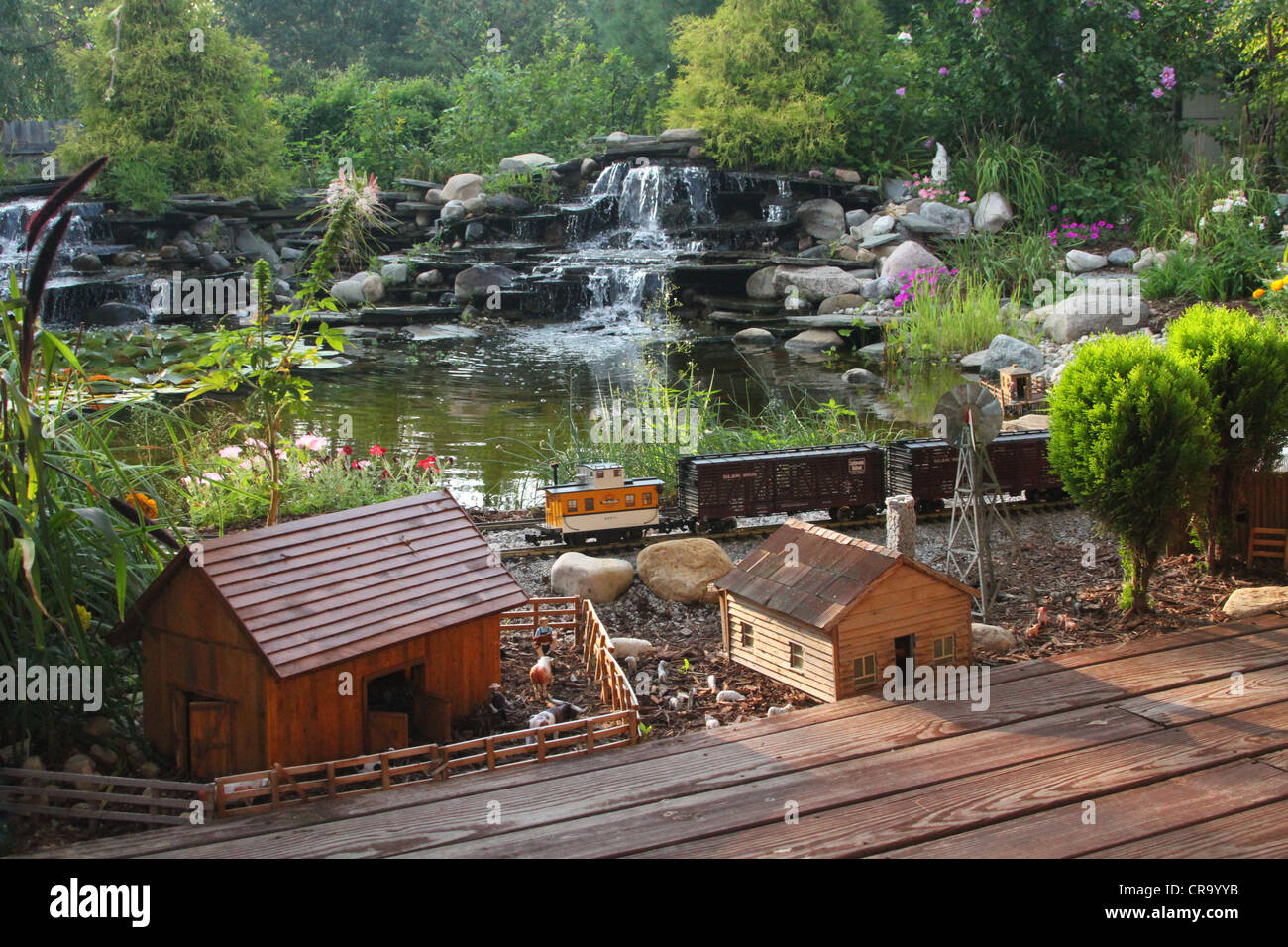A Model Garden Train passes near a Farm and near a Pond with Waterfall ...