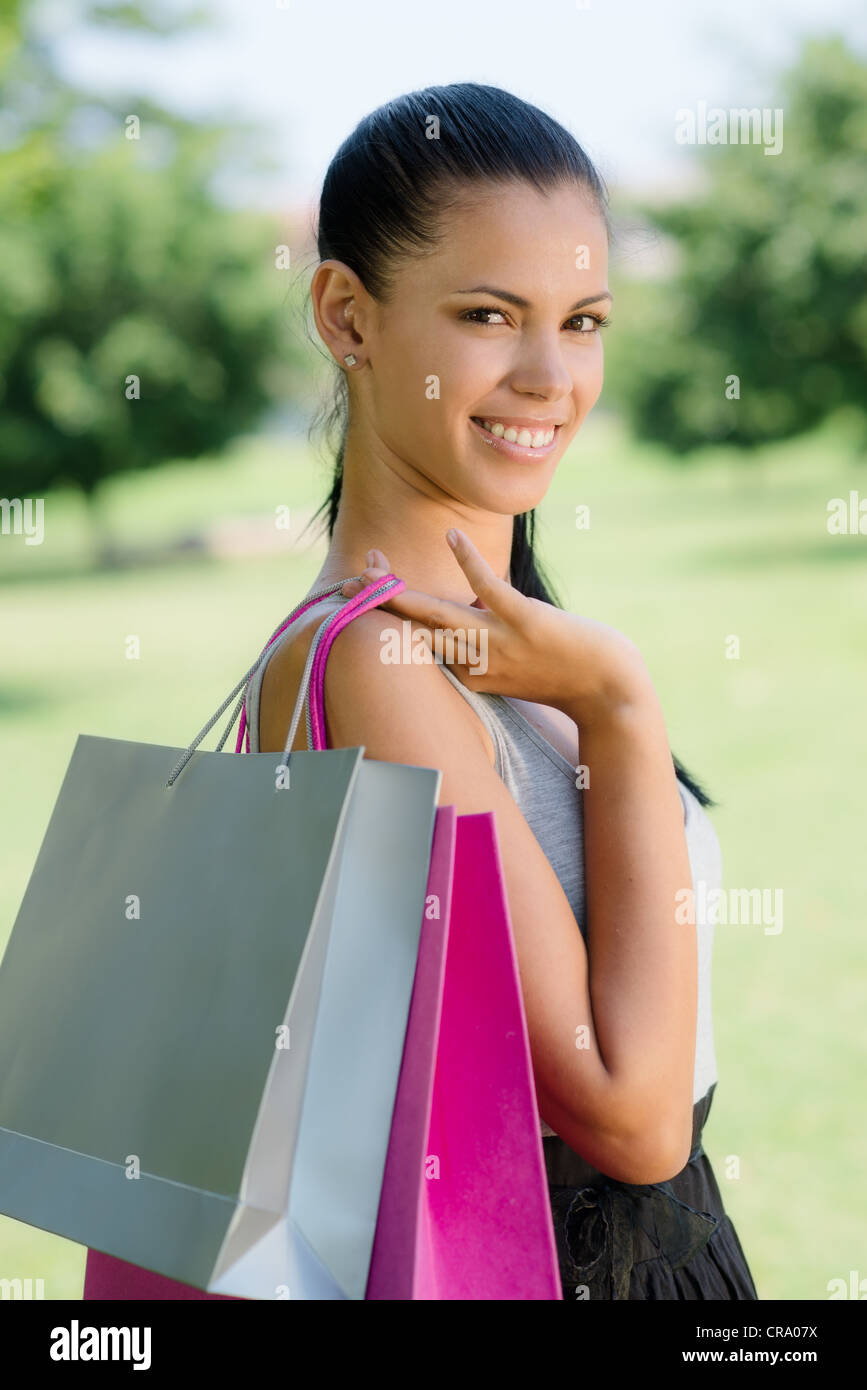 Consumerism, portrait of happy young woman smiling with shopping bags ...