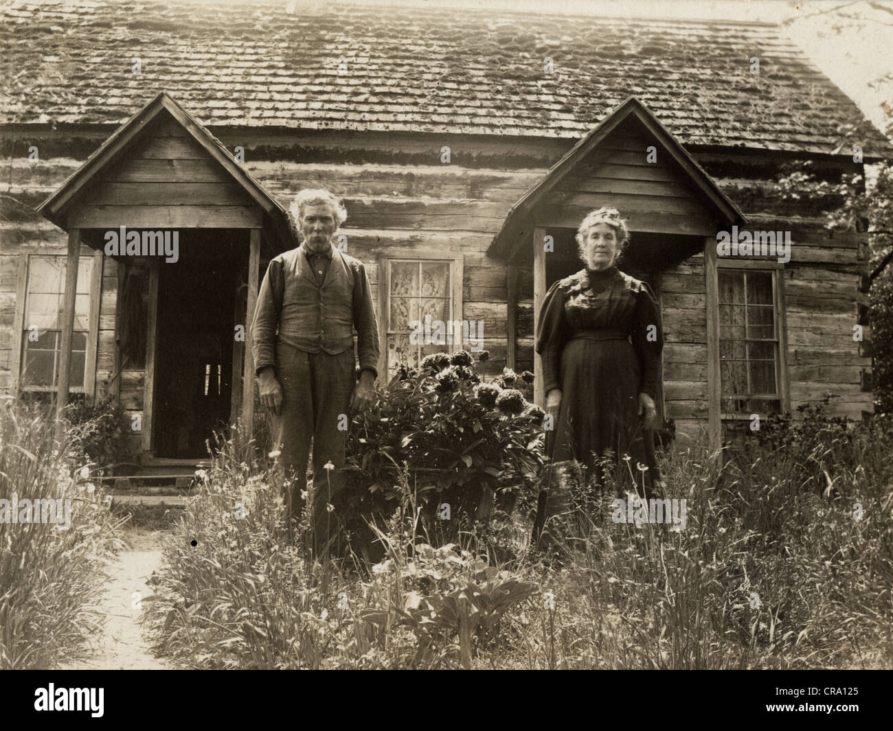Elderly Couple in front of Unusual Log Cabin Stock Photo - Alamy