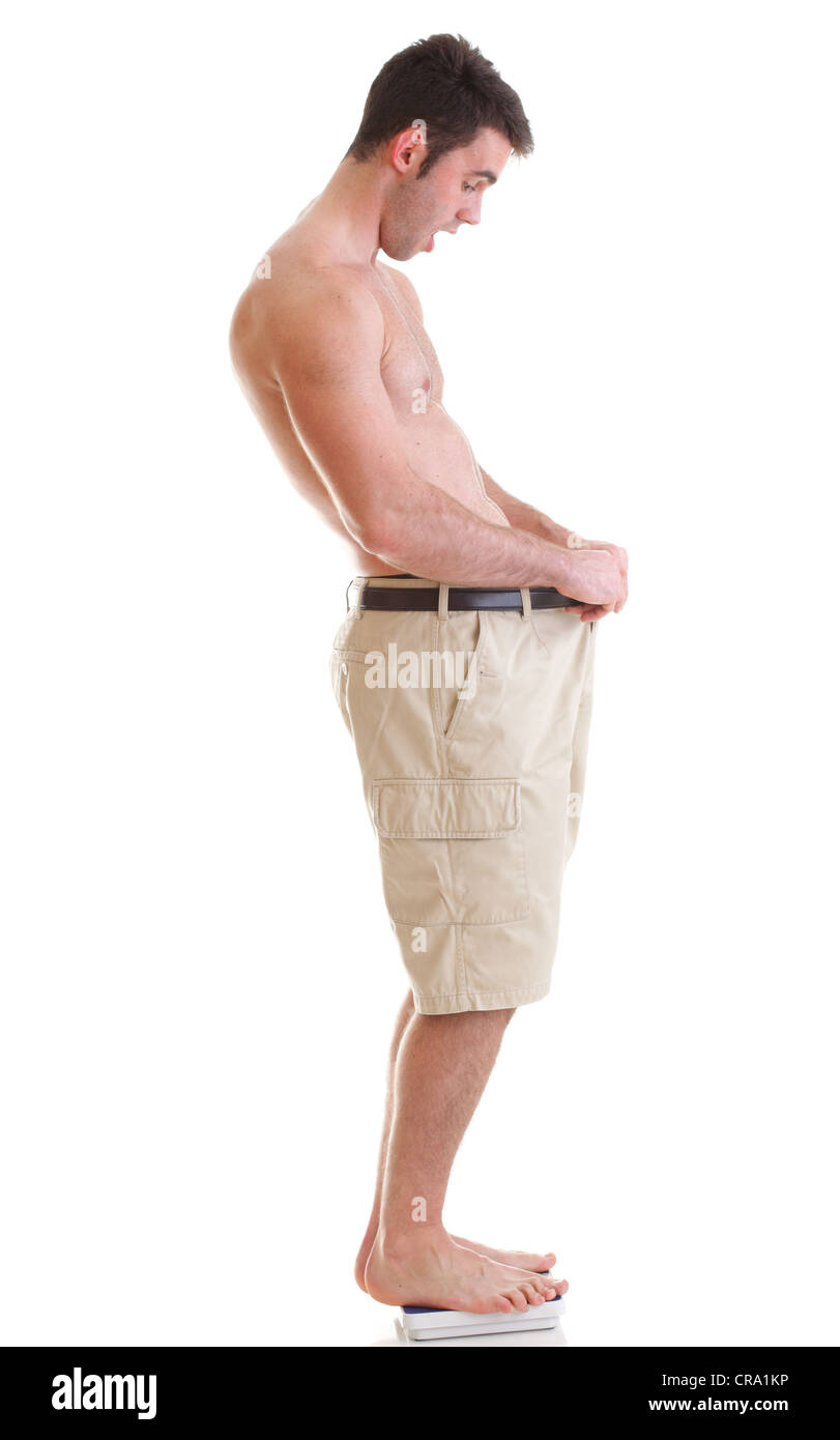 Healthy young man with a weight scale. Isolated over white background ...