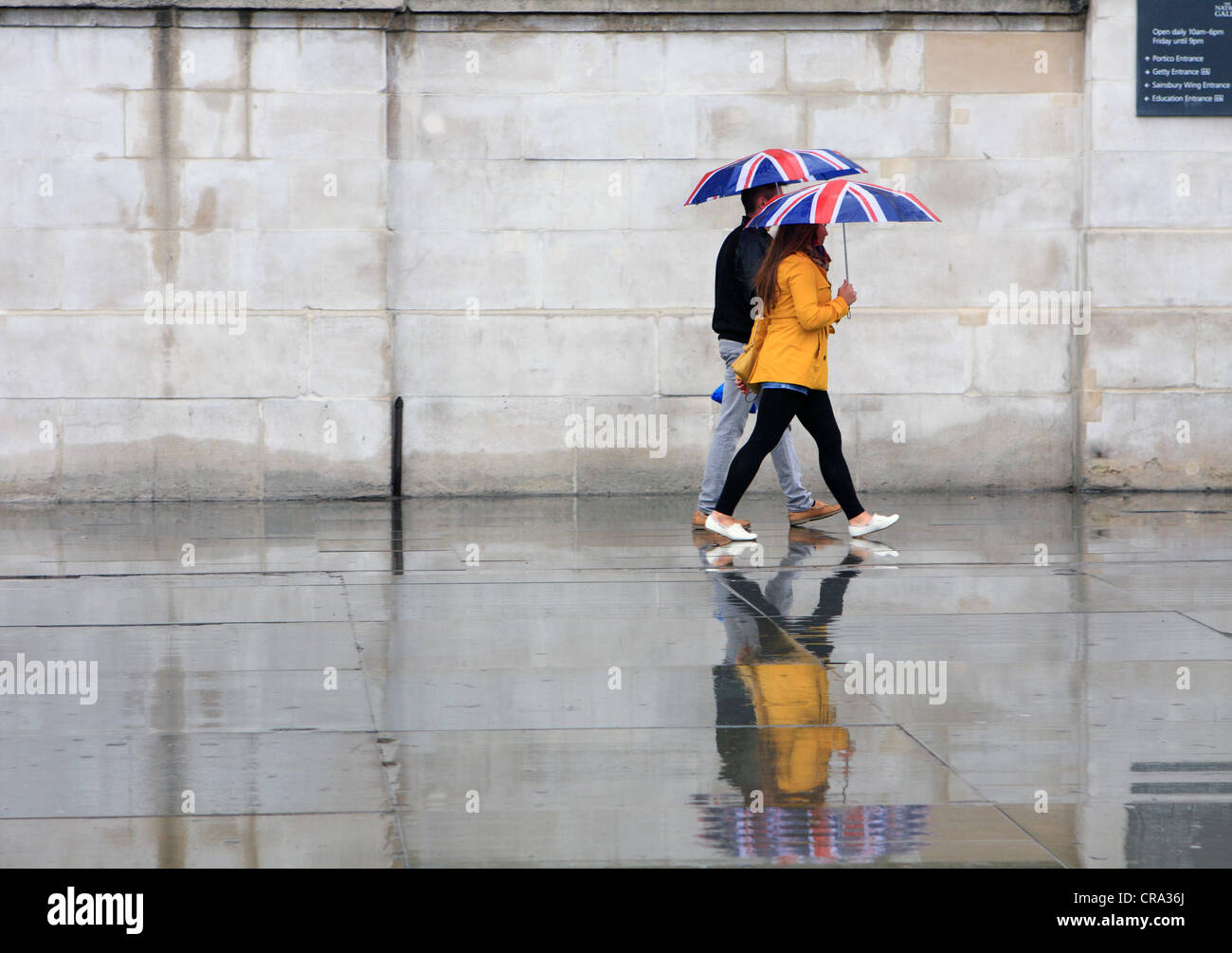 people walking passed a plain wall in the rain Stock Photo - Alamy