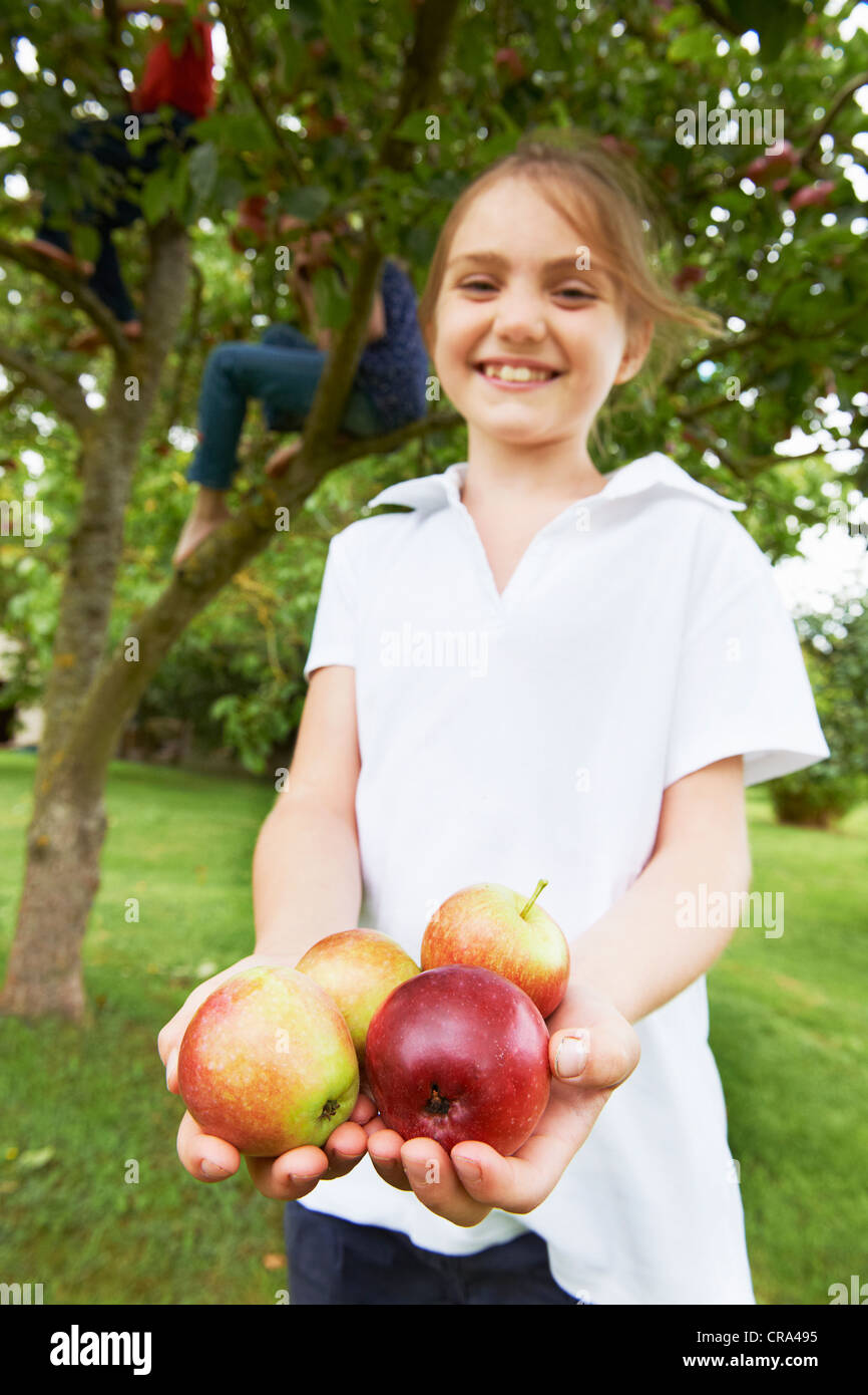 Smiling girl holding fruit outdoors Stock Photo - Alamy
