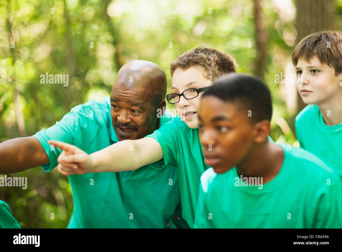 Students exploring forest with teacher Stock Photo - Alamy