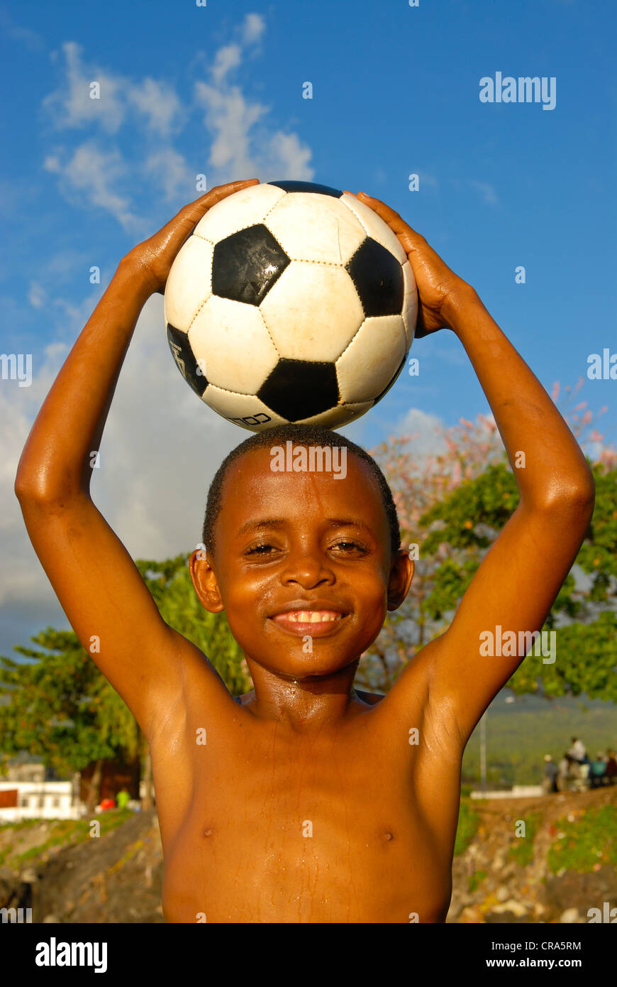 Local boy holding a football proudly in his hands, Grand Comore ...