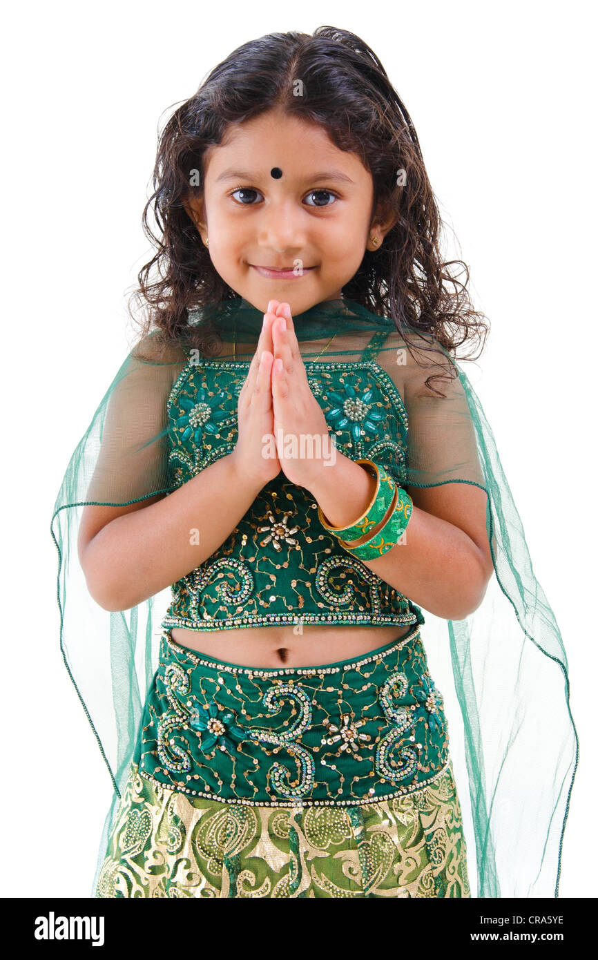 Cute little Indian girl in a greeting pose, isolated white background ...