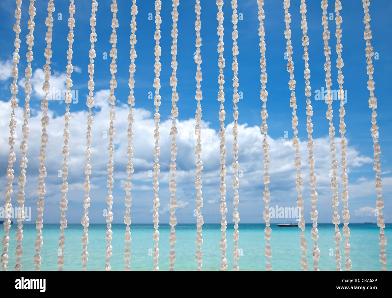 Seashell curtain and a perfect beach in background Stock Photo - Alamy