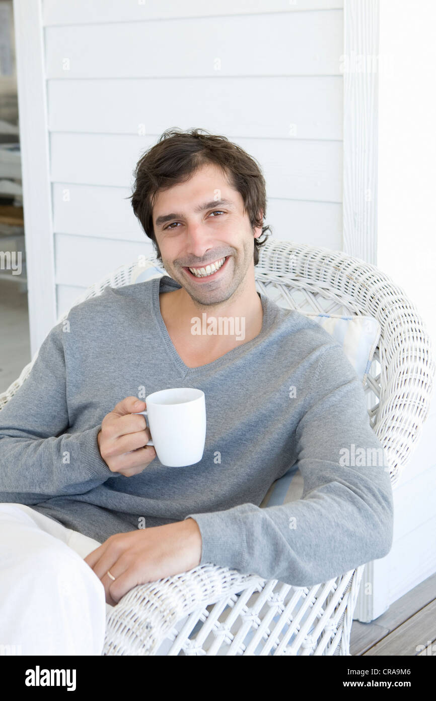 Smiling man having cup of coffee Stock Photo - Alamy