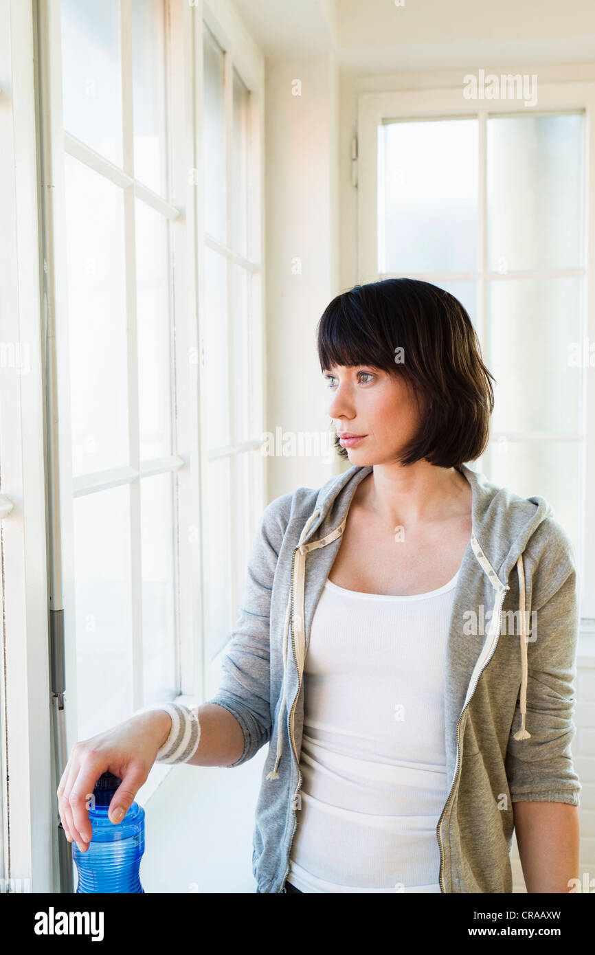 Woman standing at window Stock Photo - Alamy
