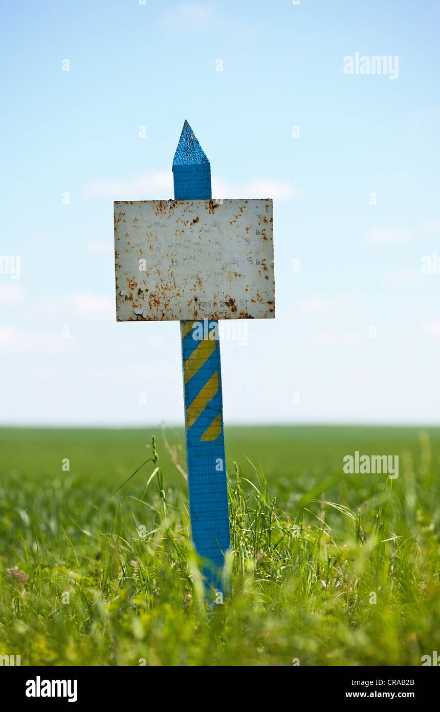 Weather-beaten sign on a grassy land plot Stock Photo - Alamy