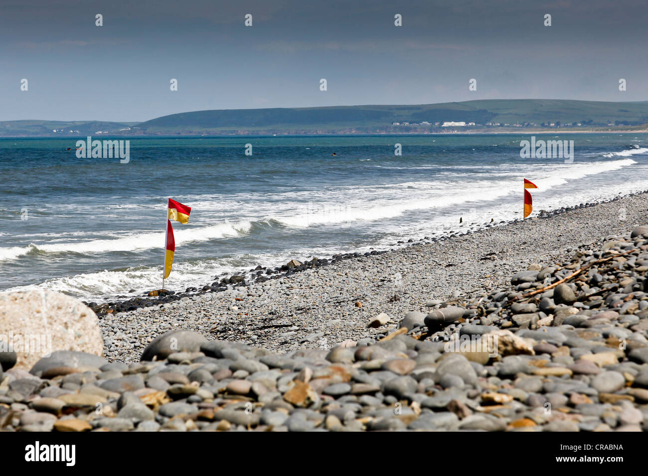 A dramatic shoreline with flags indicating the safe area to swim Stock ...