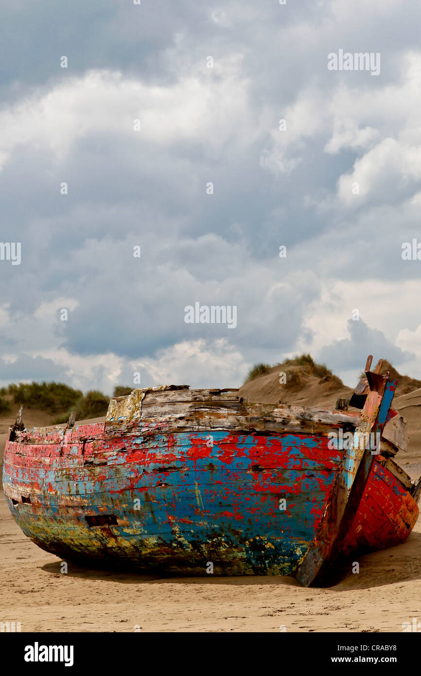 A colourful wreck of a former trawler stranded on a sandy beach Stock ...