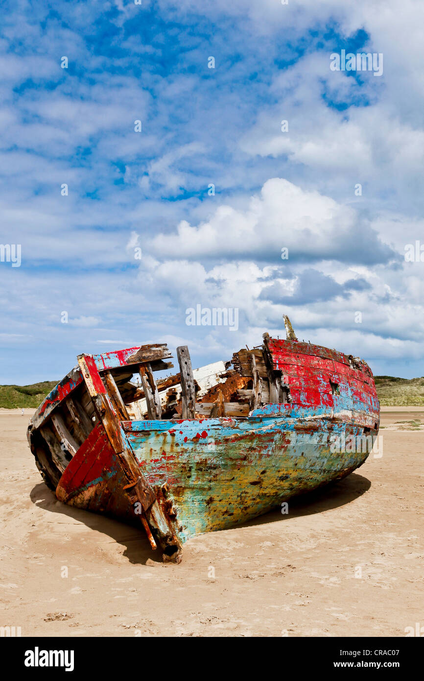 A colourful wreck of a former trawler stranded on a sandy beach Stock ...