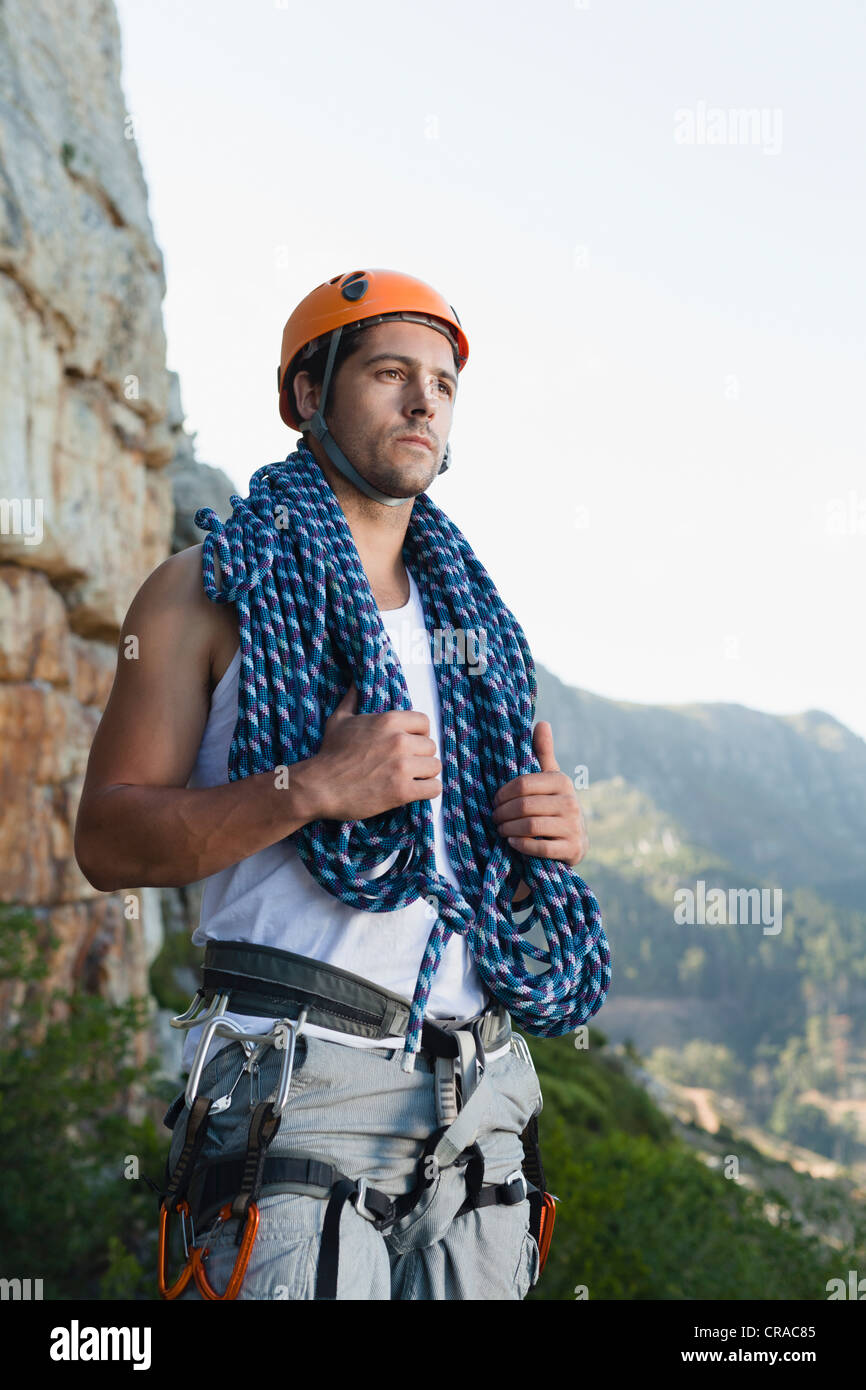 Climber holding coiled rope on mountain Stock Photo - Alamy