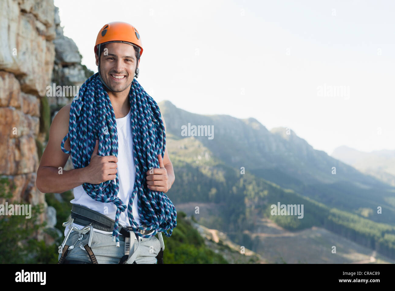 Climber holding coiled rope on mountain Stock Photo - Alamy