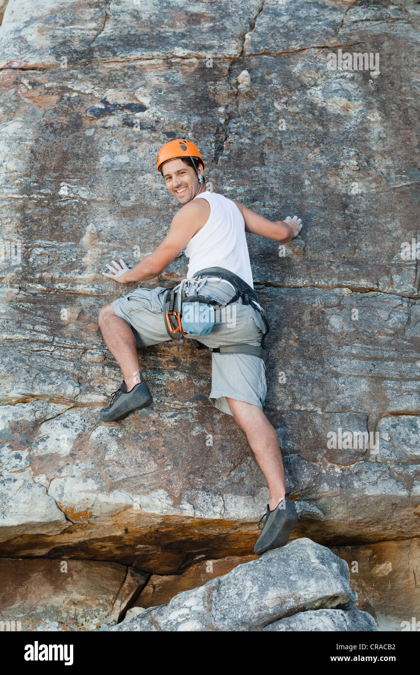 Climber scaling steep rock face Stock Photo - Alamy