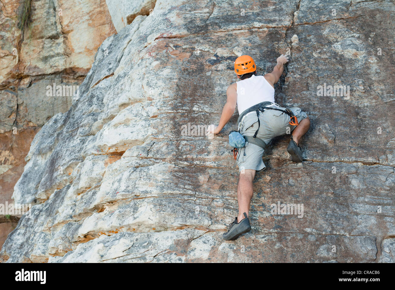 Climber scaling steep rock face Stock Photo - Alamy