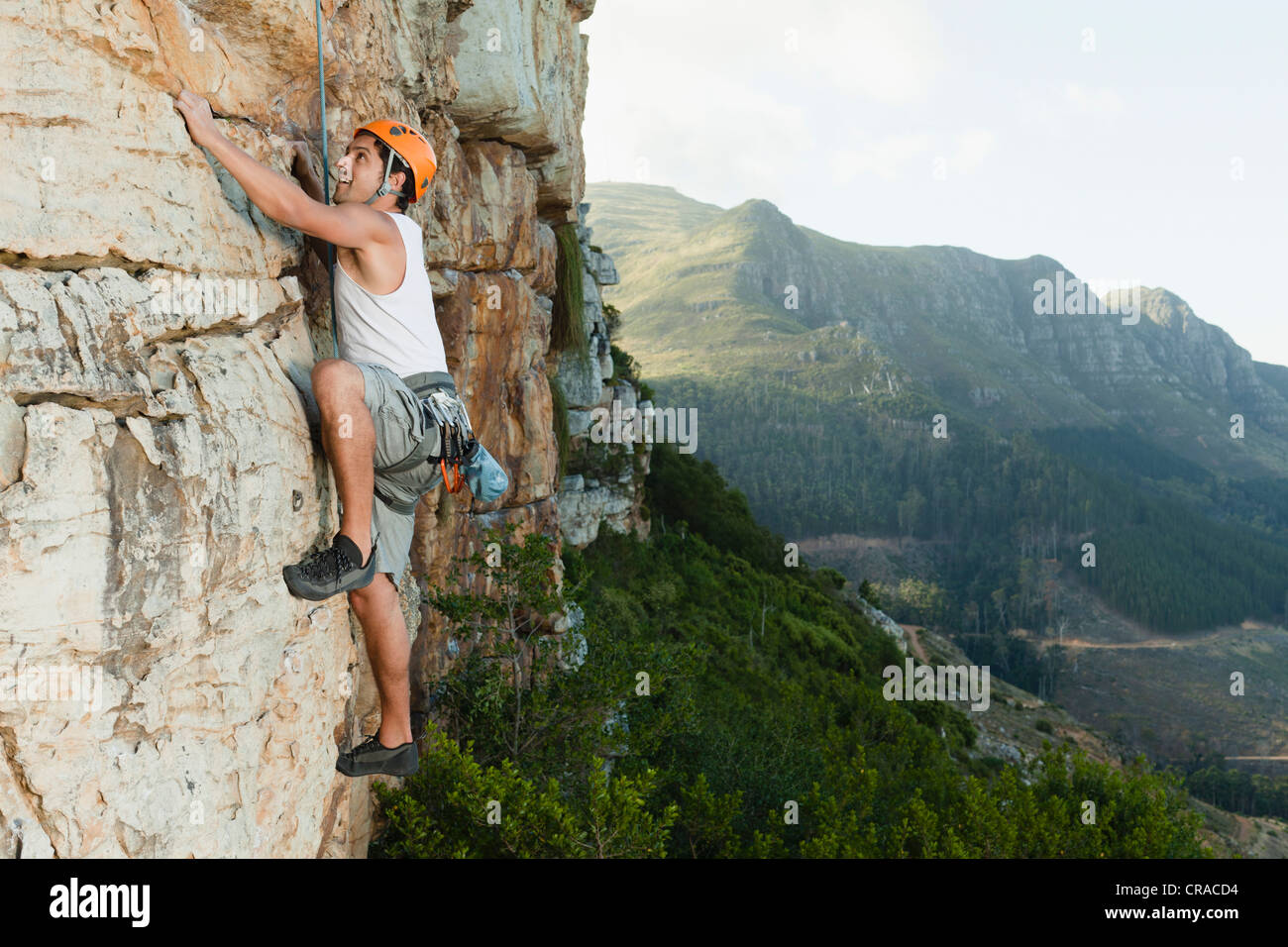 Climber scaling steep rock face Stock Photo - Alamy