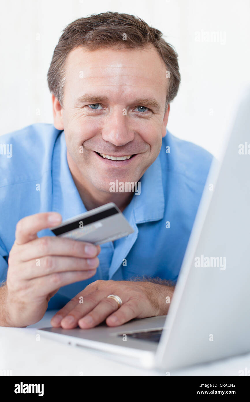 Man shopping online on bed Stock Photo - Alamy