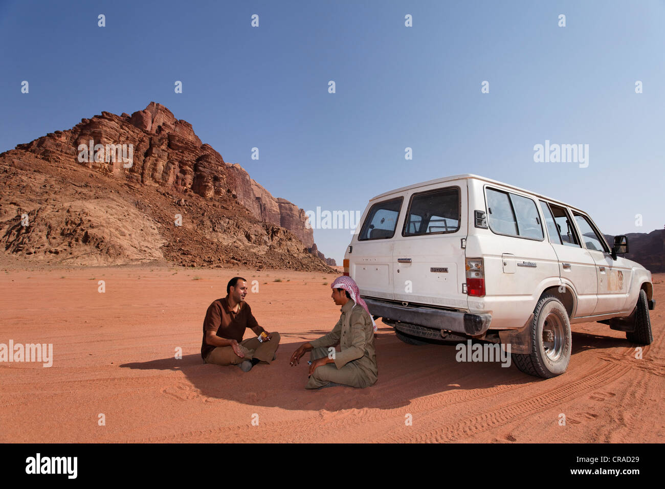 Bedouins and Jordanian resting in the shade of an off-road vehicle in ...