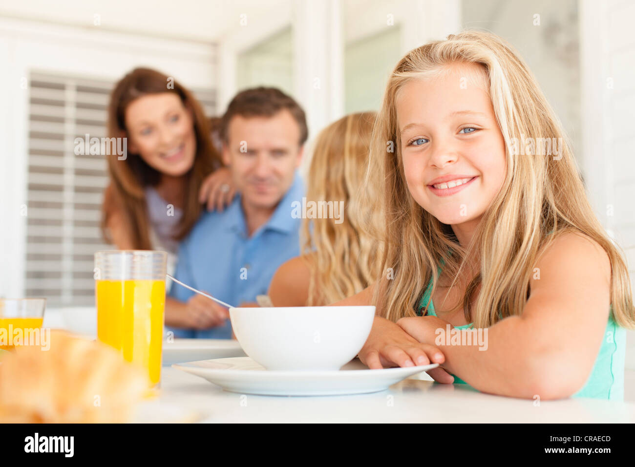Smiling girl sitting at breakfast table Stock Photo - Alamy